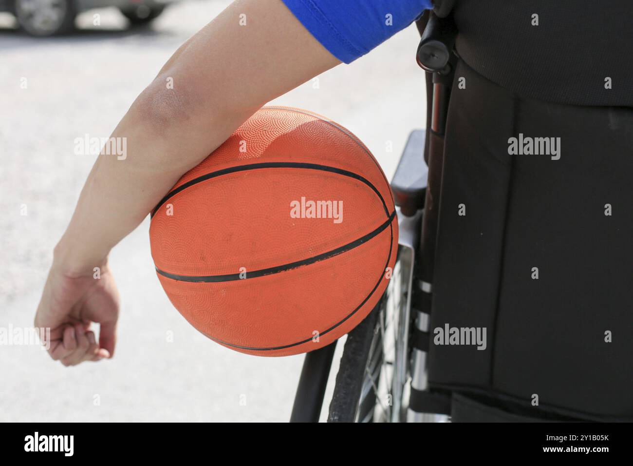 Disabled young basketball player on a wheelchair holding ball and ...