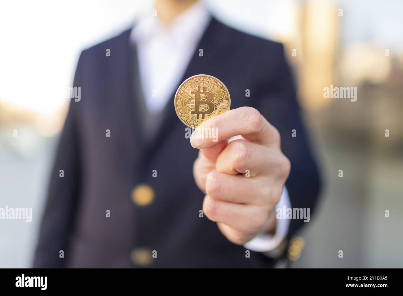 Bitcoin cryptocurrency coin in a young businessman hand. Disruptive ...