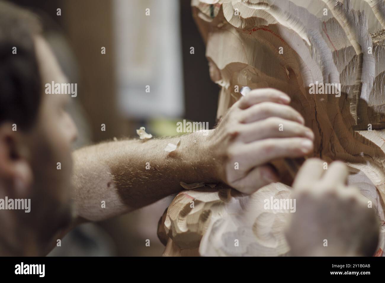 A close-up of a craftsman chiseling precise details into a wooden ...