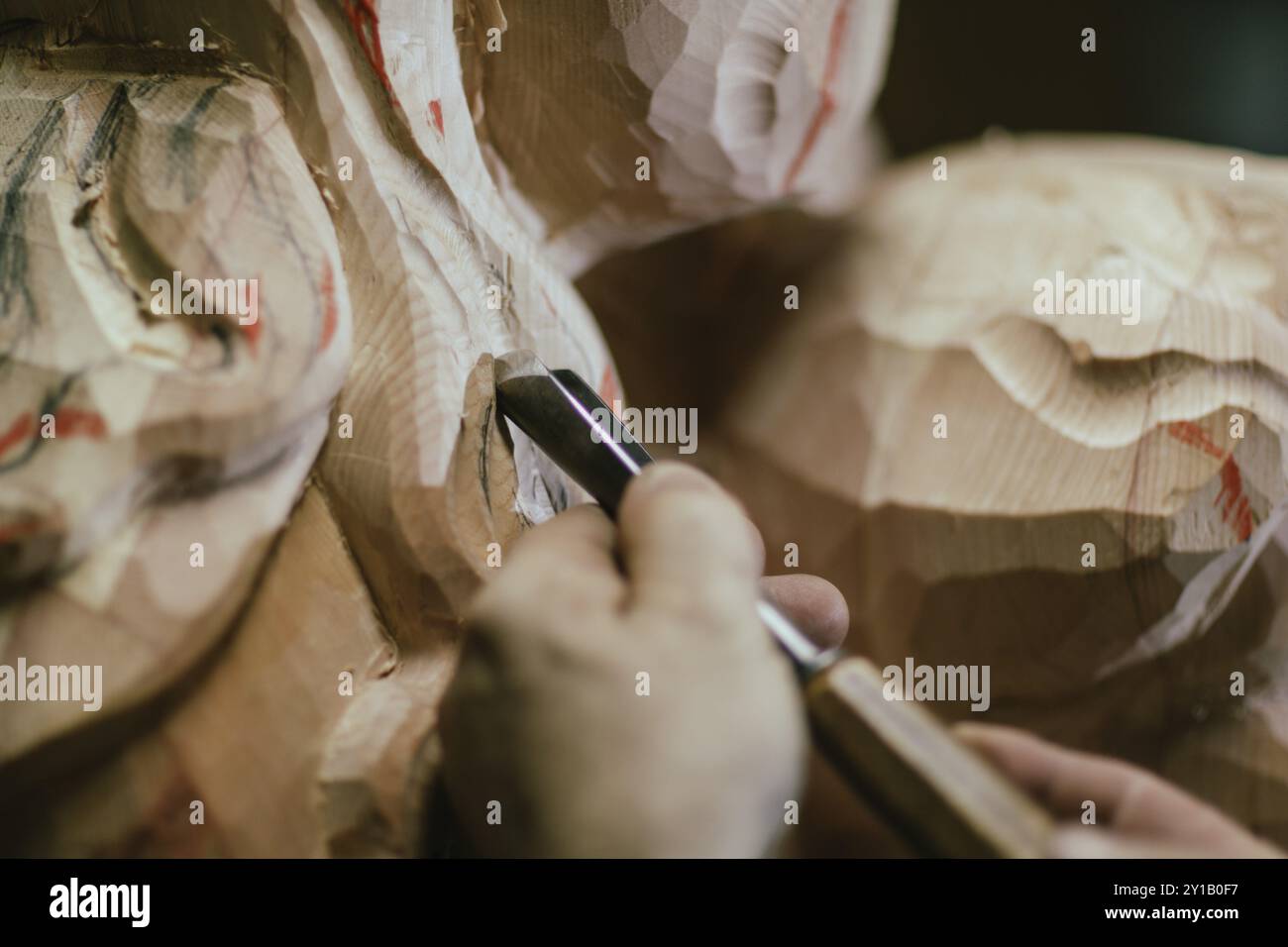 Close-up of a craftsman's hands using a chisel to carve intricate ...