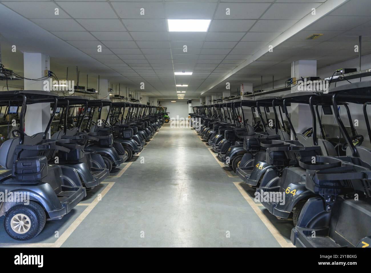 Interior full length view of a row of golf cart parking in golf course ...