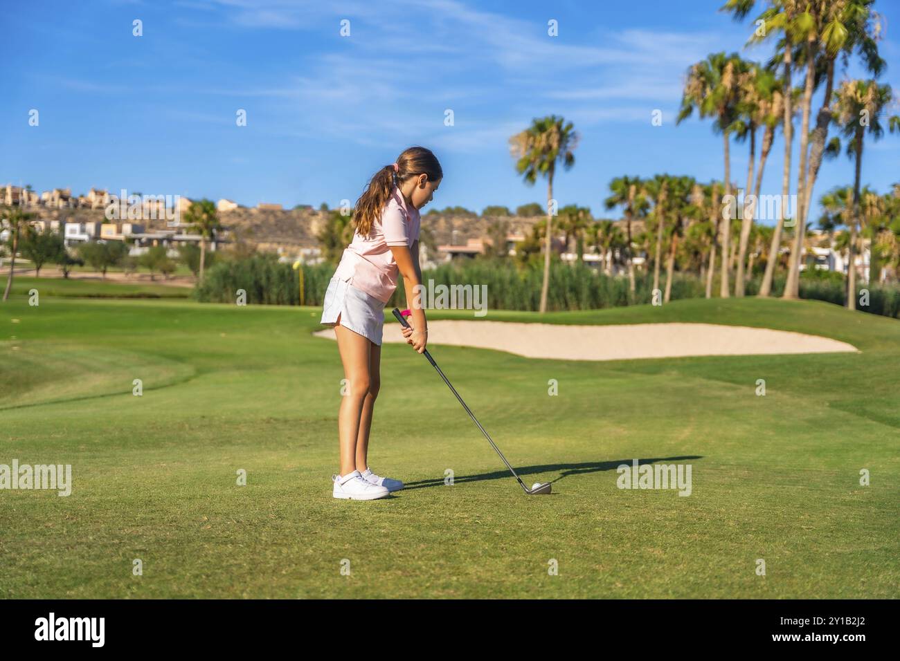 Full length photo of a little blonde girl playing golf in a luxury ...