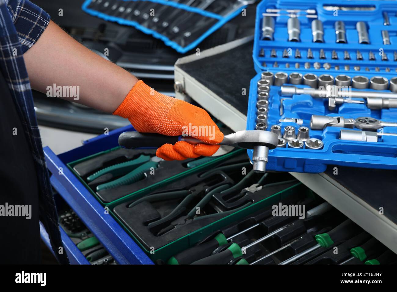 Auto mechanic with torque wrench and different tools at automobile ...