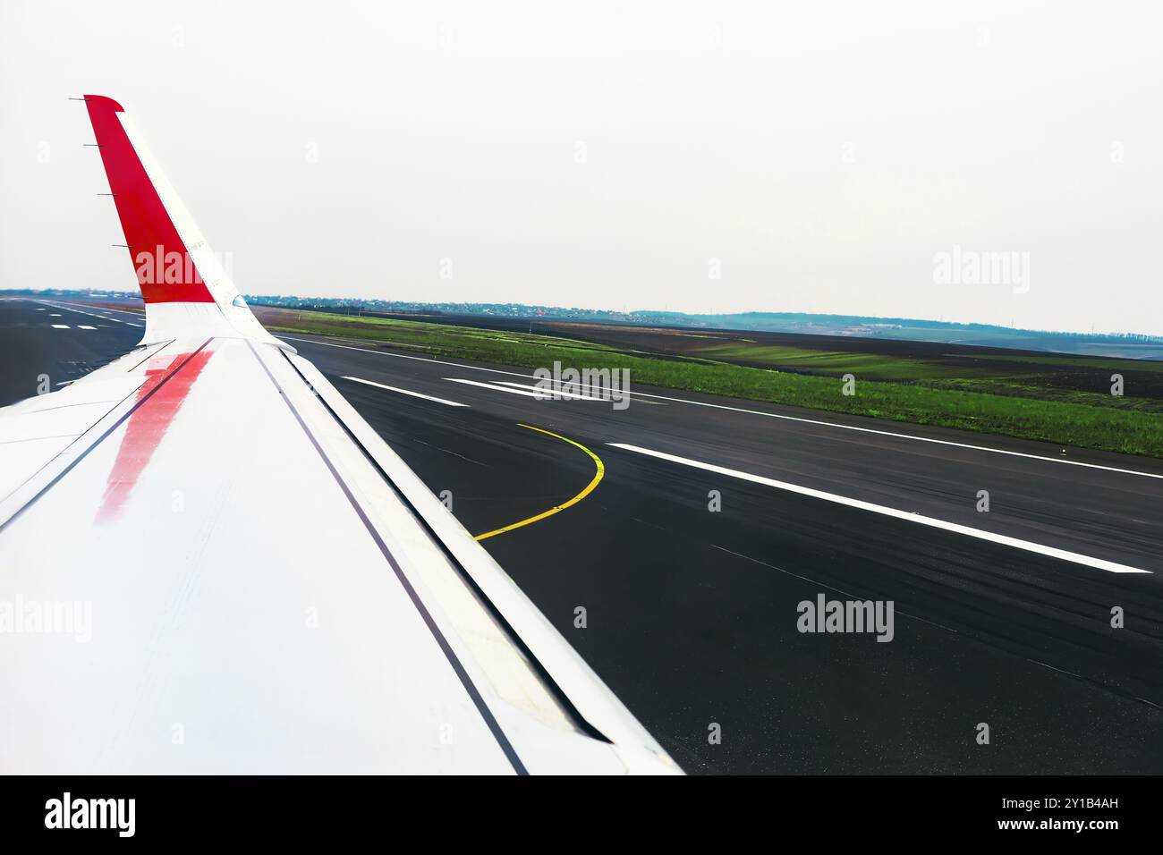 Airplane wing extends over the runway. Plane aerodynamic structure and ...