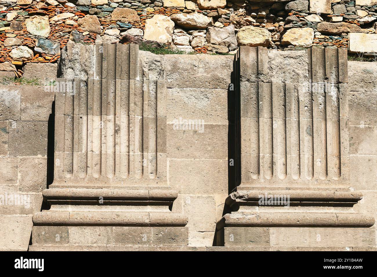 Ancient stone pillars with a lot of cracks on the wall. Robust stone ...