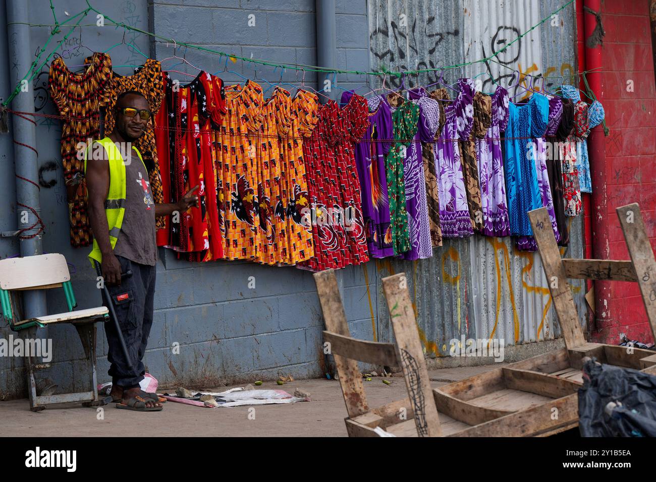 A security guard stands outside a stall at a market in Port Moresby ...