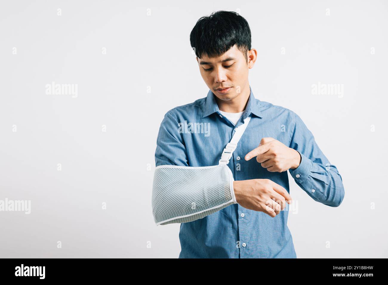 Portrait Asian smiling young man wearing a cast on his arm broken ...