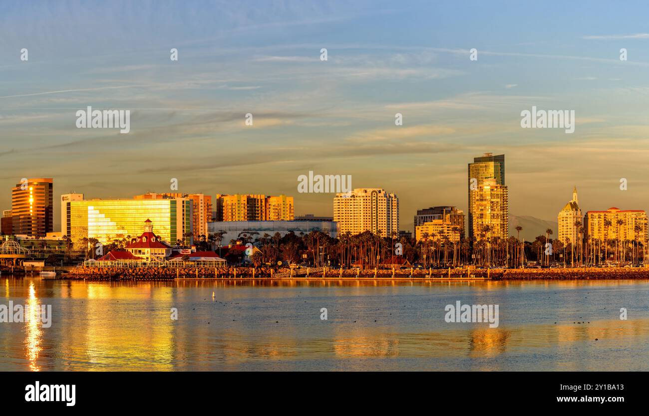 The Long Beach skyline glows under the golden hour light, with the calm ...