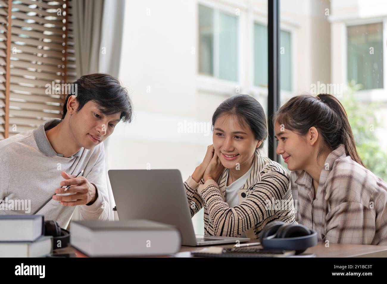 Group discussion around laptop enhances learning process Stock Photo ...