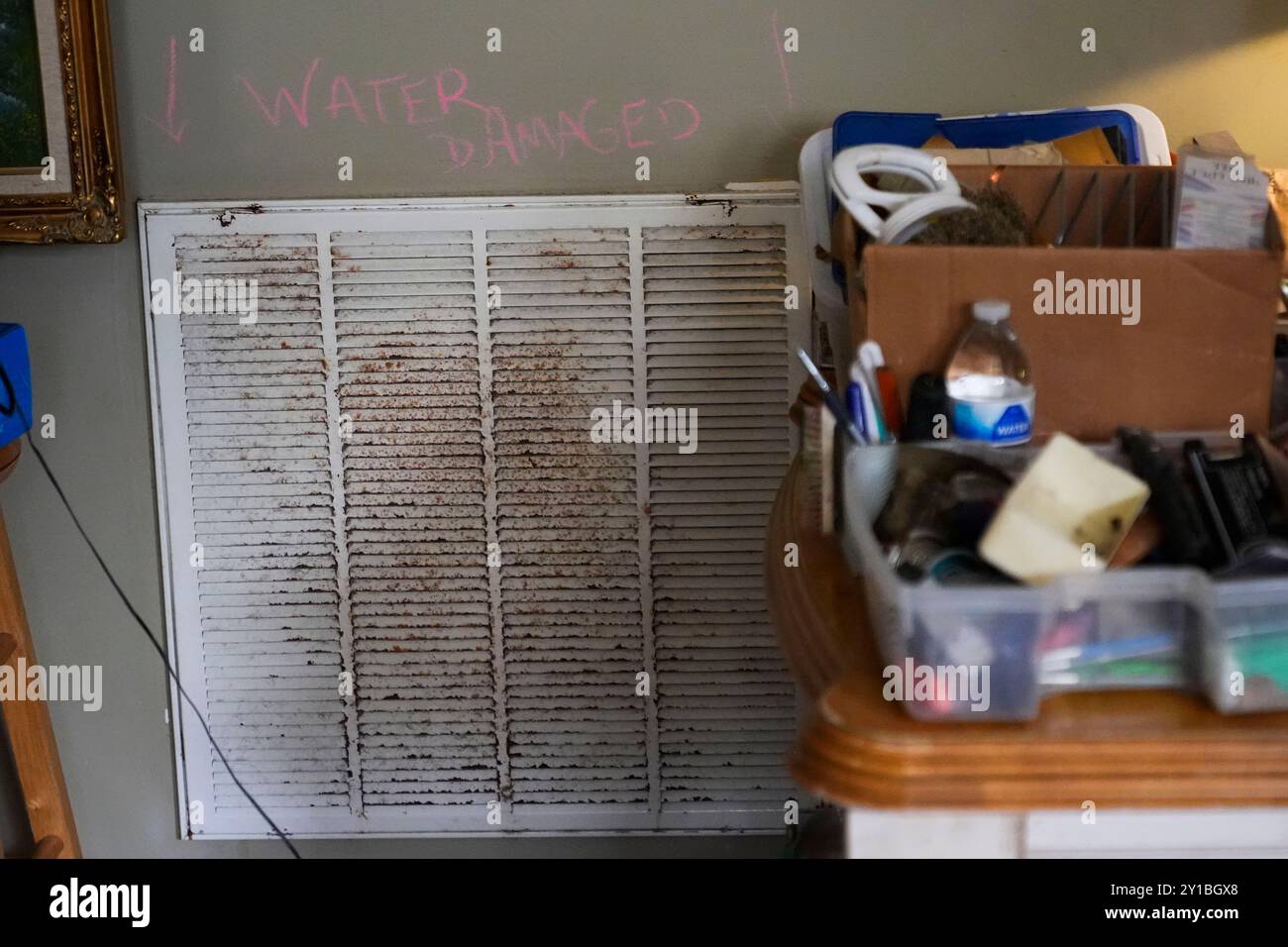 A water damaged air conditioner intake is marked inside the home of ...