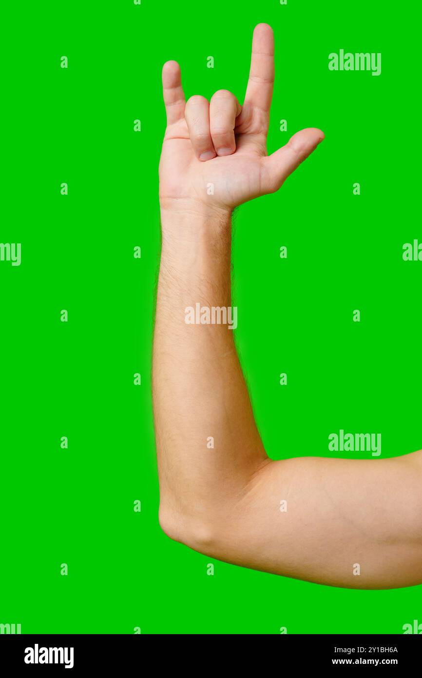 Person Making Hand Gesture Against Bright Green Background in Daylight ...