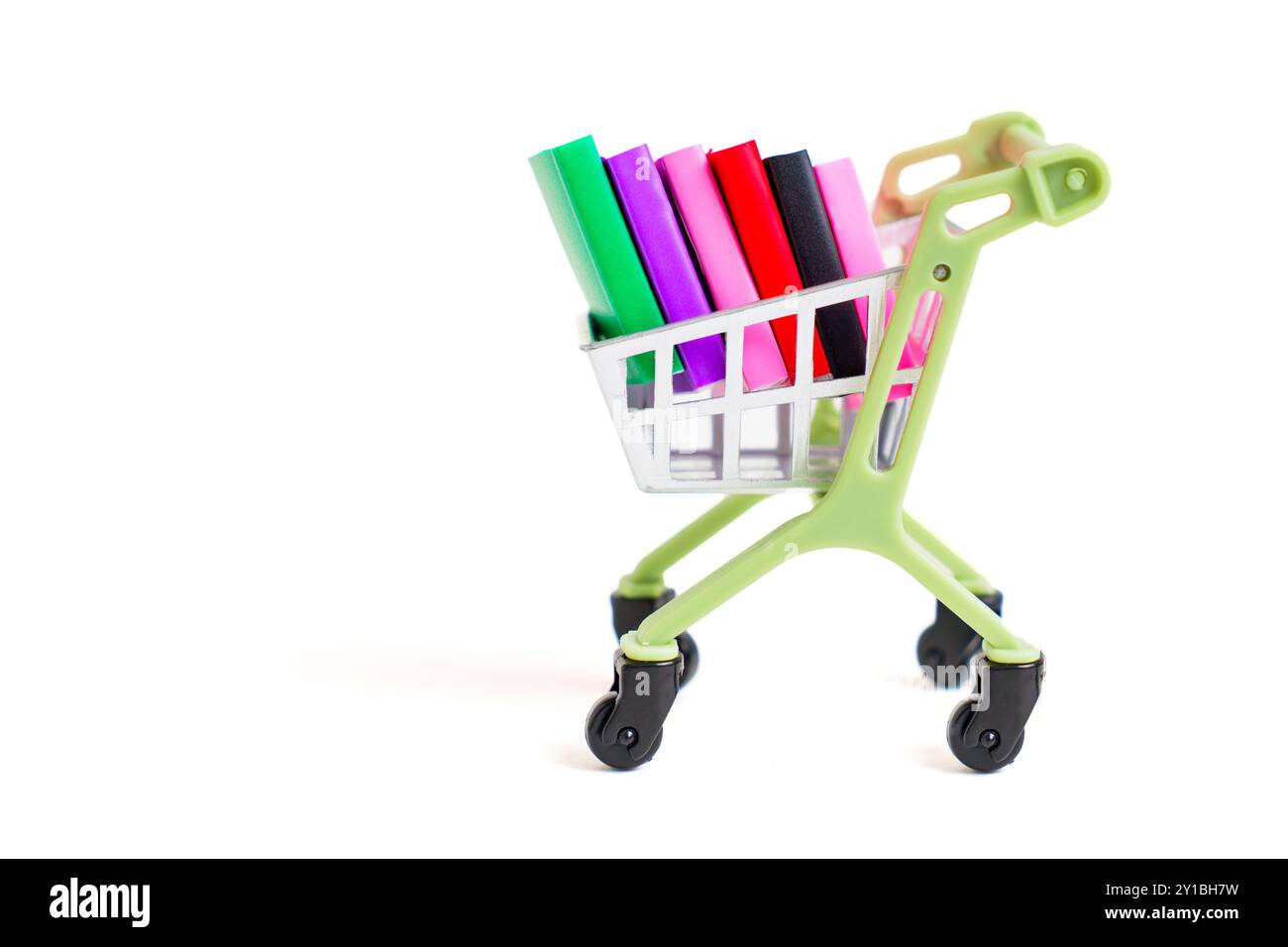 Mini shopping cart filled with vibrant colored books isolated on white ...