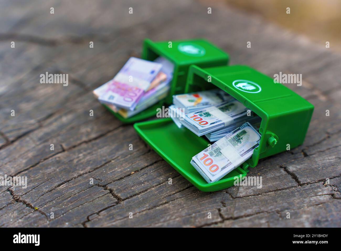 Green bins filled with various euro and dollar bills illustrating the ...