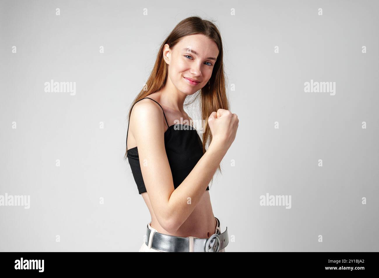 Young Woman Posing With Fists Up Celebrating Success Stock Photo - Alamy