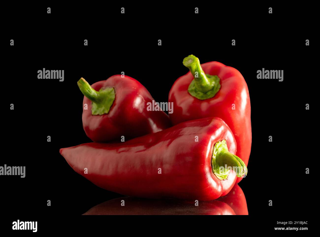 Three sweet red peppers, macro, isolated on black background Stock ...