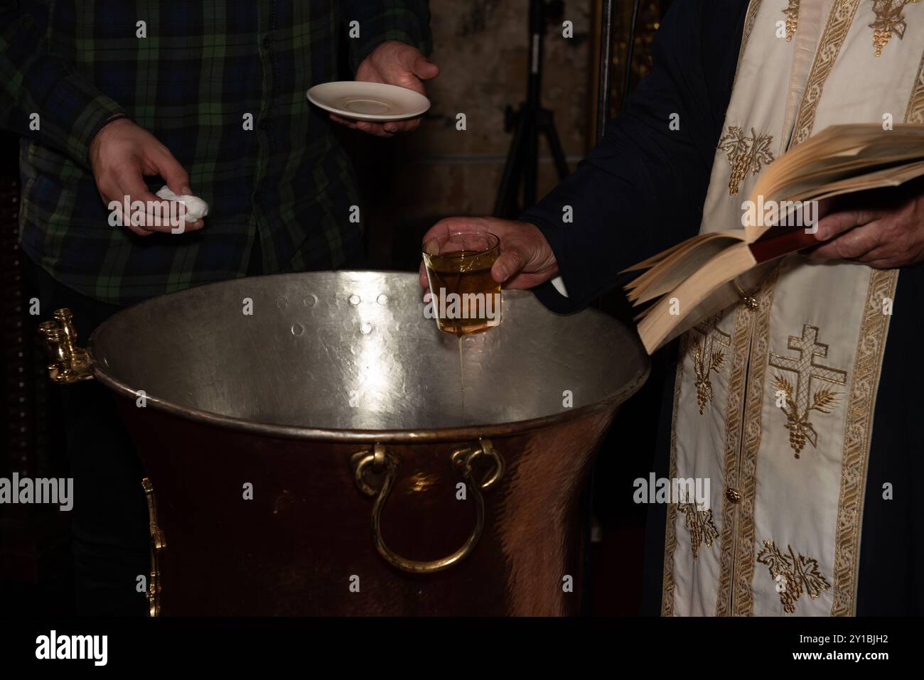 Priest reading wishes from bible during baptism ceremony in a church ...