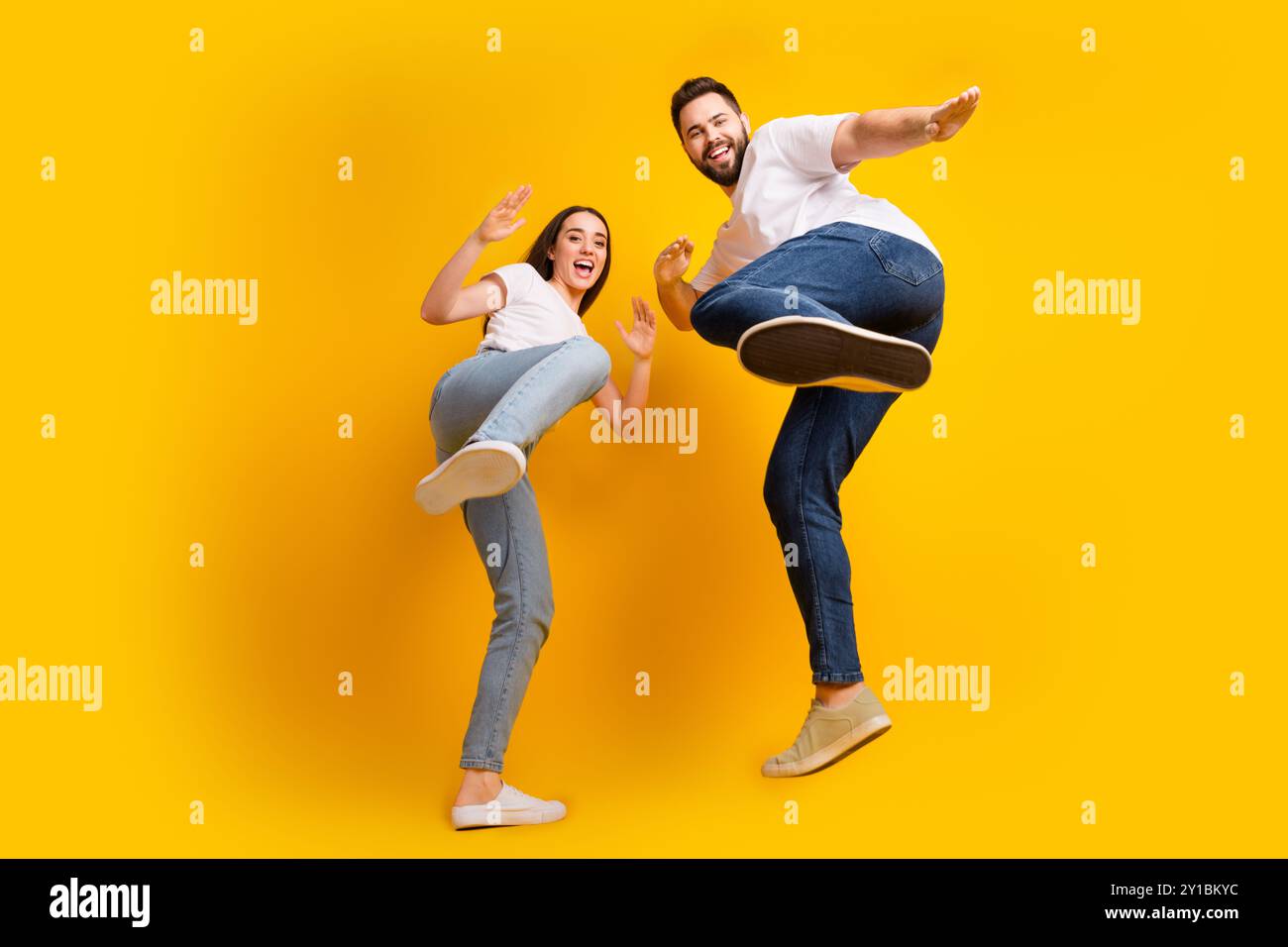 Full length photo of lovely young guy girl kick legs have fun fight ...