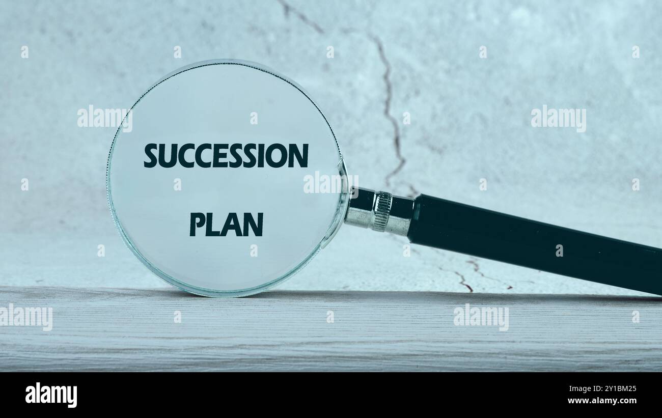 SUCCESSION PLAN word alphabet letters through a magnifying glass on a ...