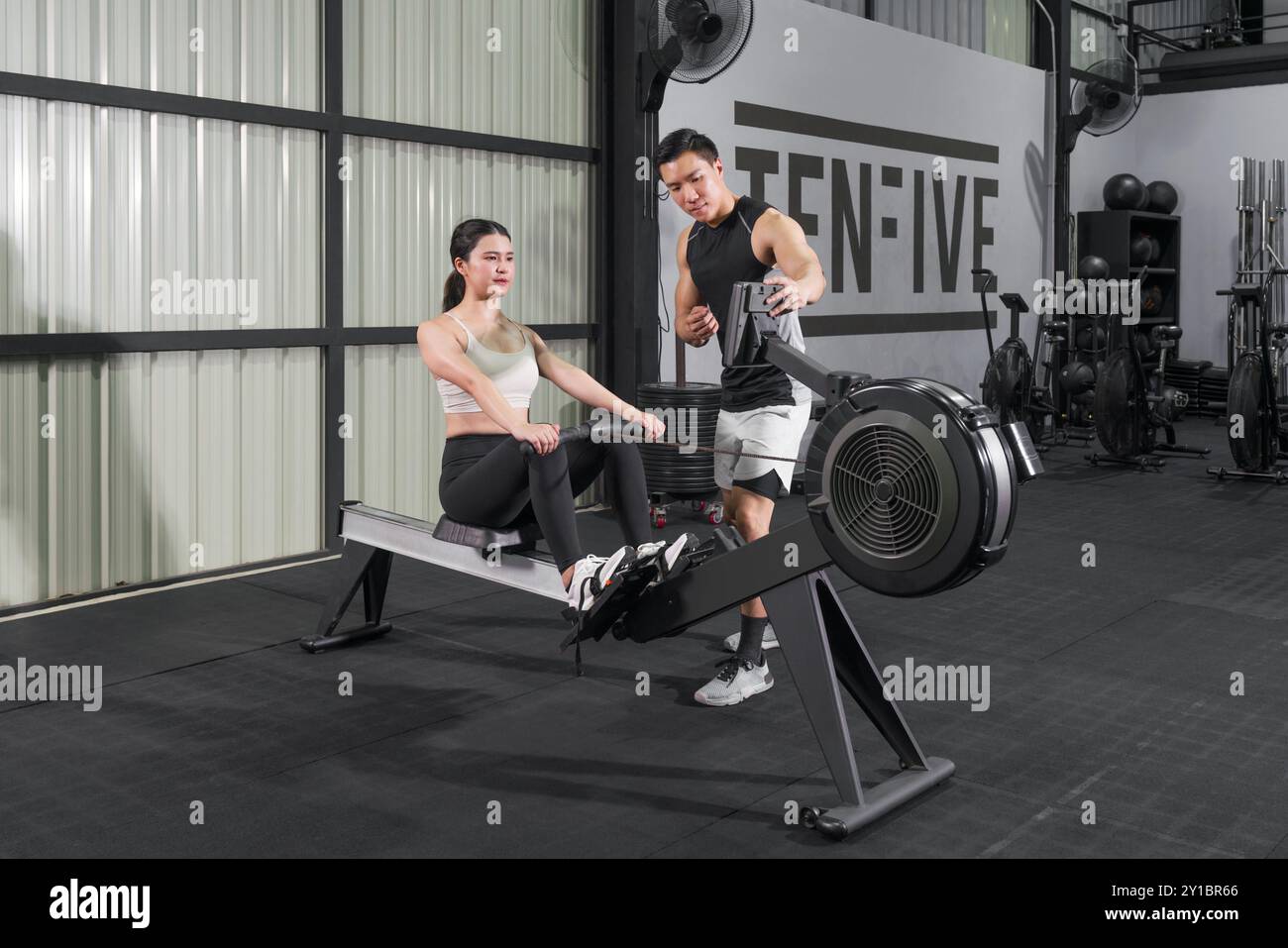 An athletic woman in sportswear is engaged in an intense workout ...