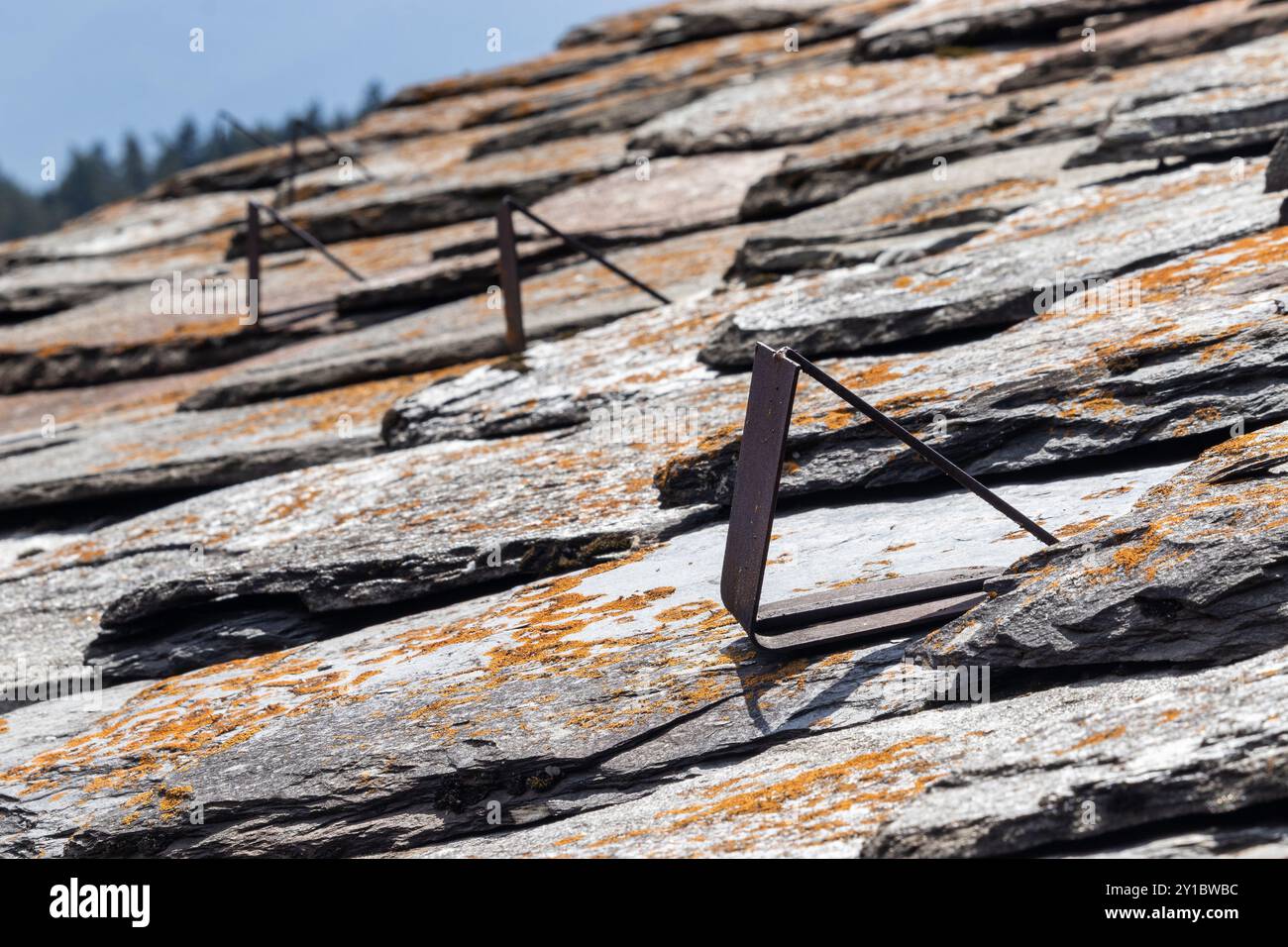 Close up view of old metal snow guards on a slate roof in the Italian ...