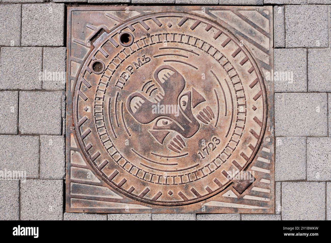 Cast iron round cover for manhole on sidewalk in Perm. Image of symbol ...