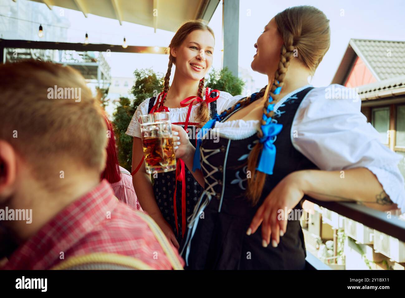 Two beautiful young women in traditional Bavarian clothes, waitress ...
