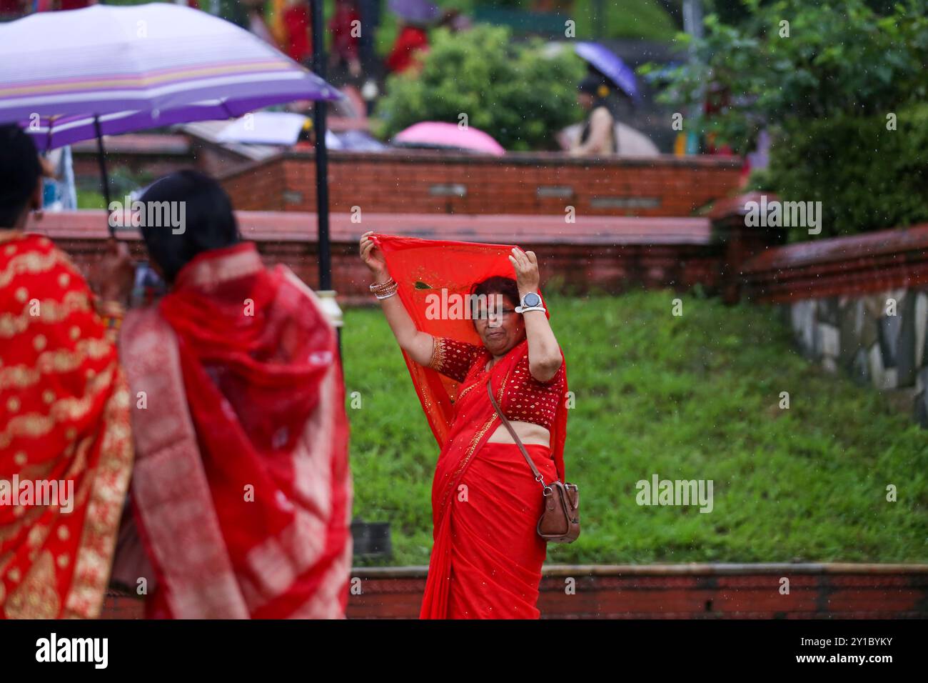 A fasting Nepali Hindu woman dressed in red poses for a photo at ...