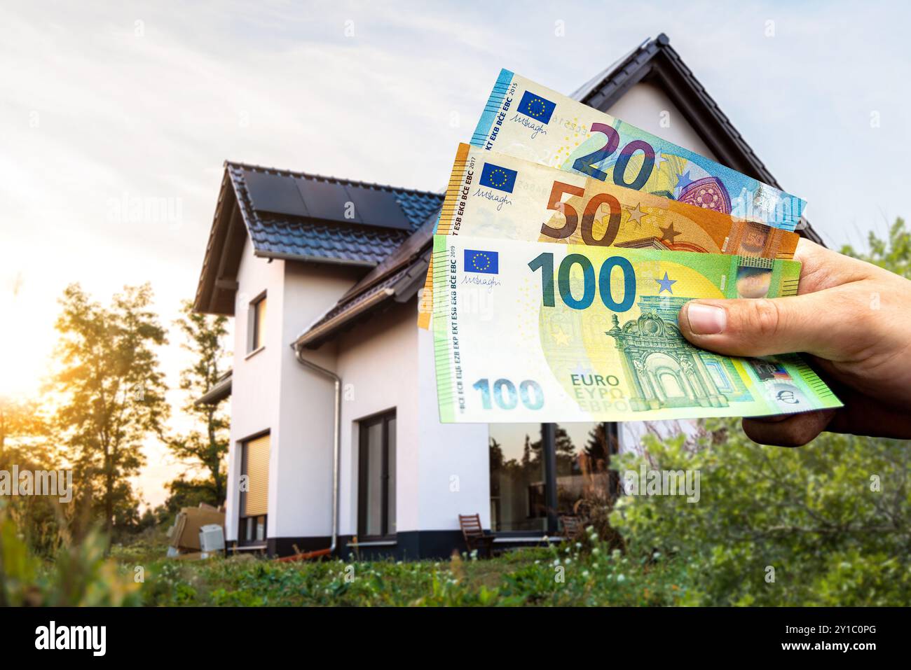 Hand Holding Euro Banknotes in Front of a New Single Family Home with a ...