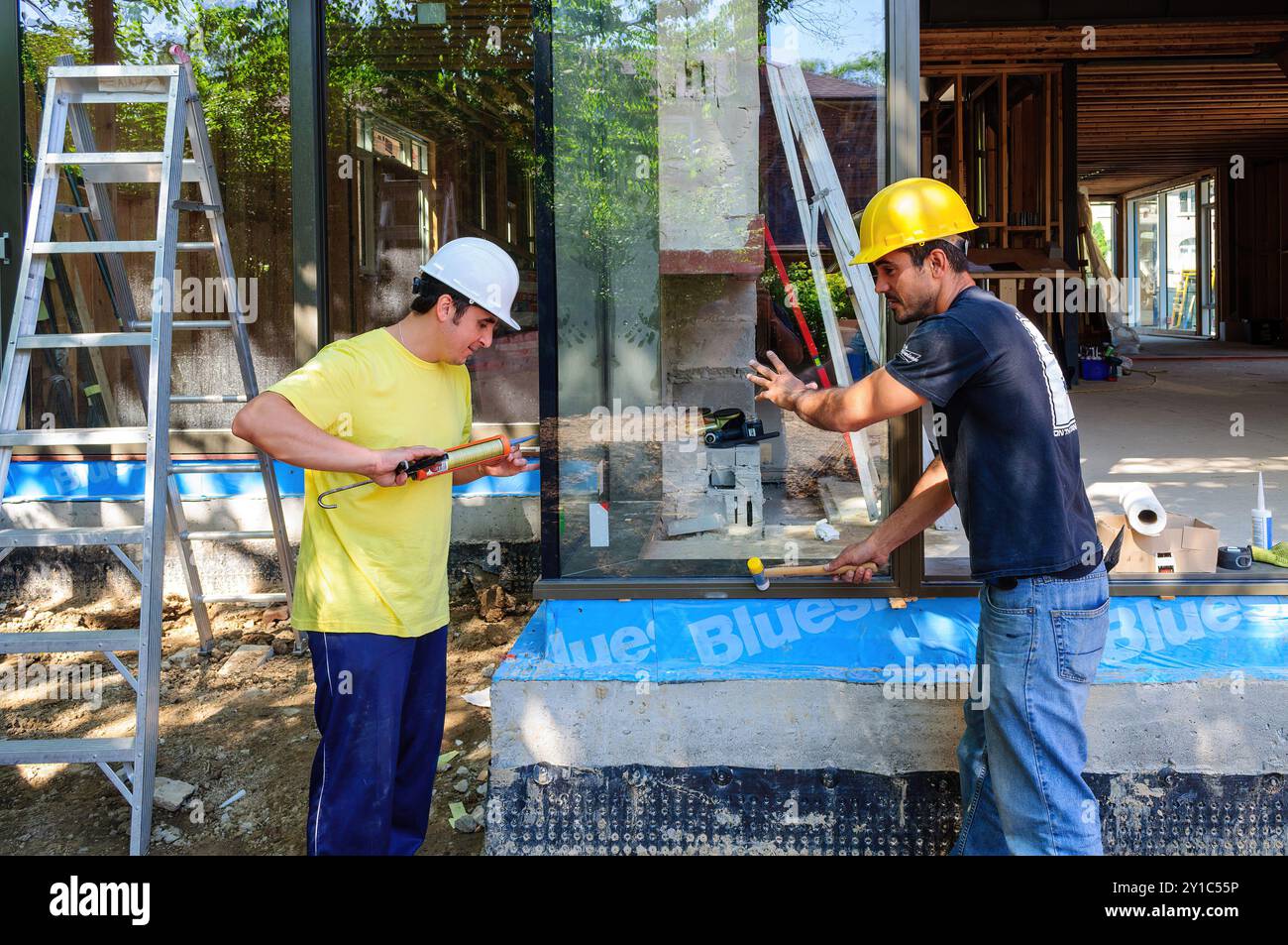 Installing European style windows in a house construction site, Toronto ...