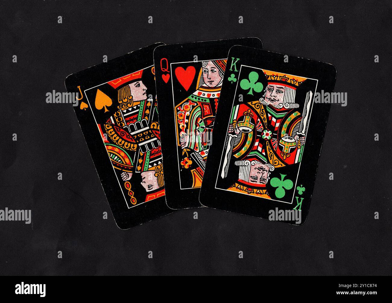 Vintage black playing cards showing a jack, queen and king on a black ...