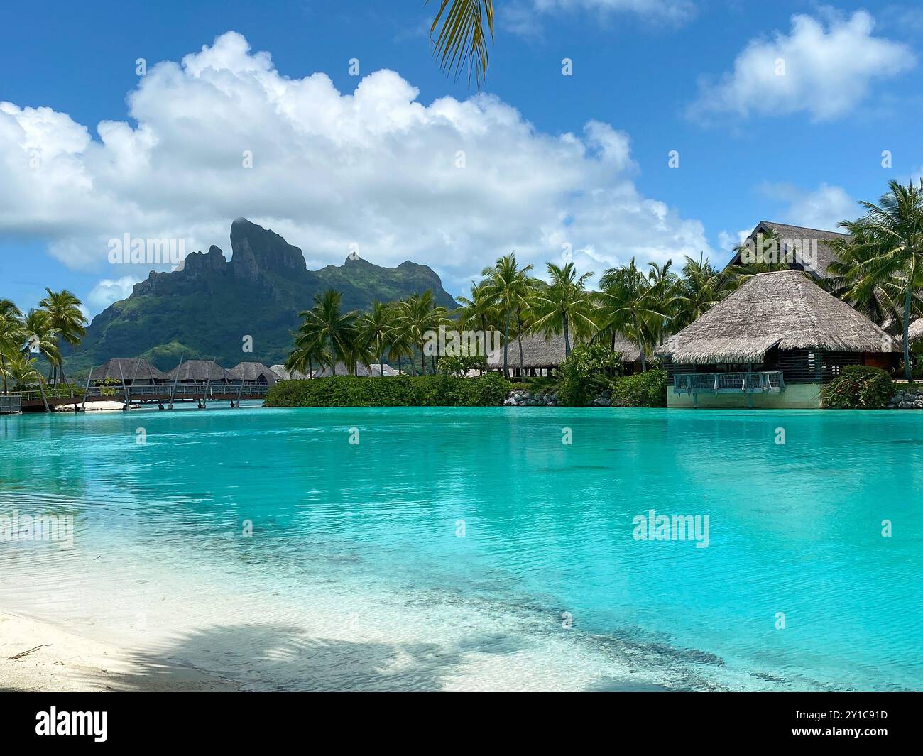 View of the Mount Otemanu through turquoise lagoon, palm trees and ...