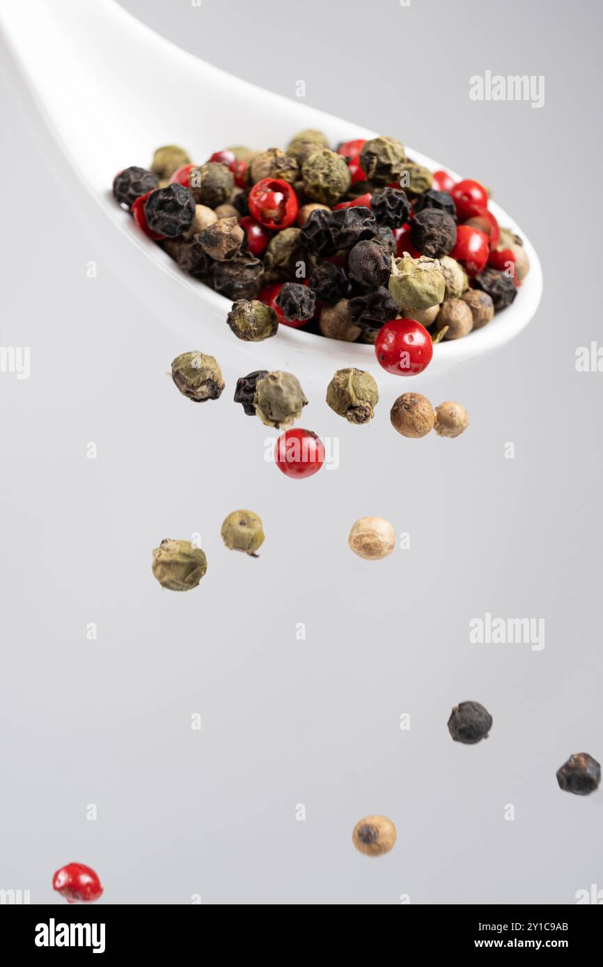 Different types of peppercorns pouring. Red, green, white and black ...