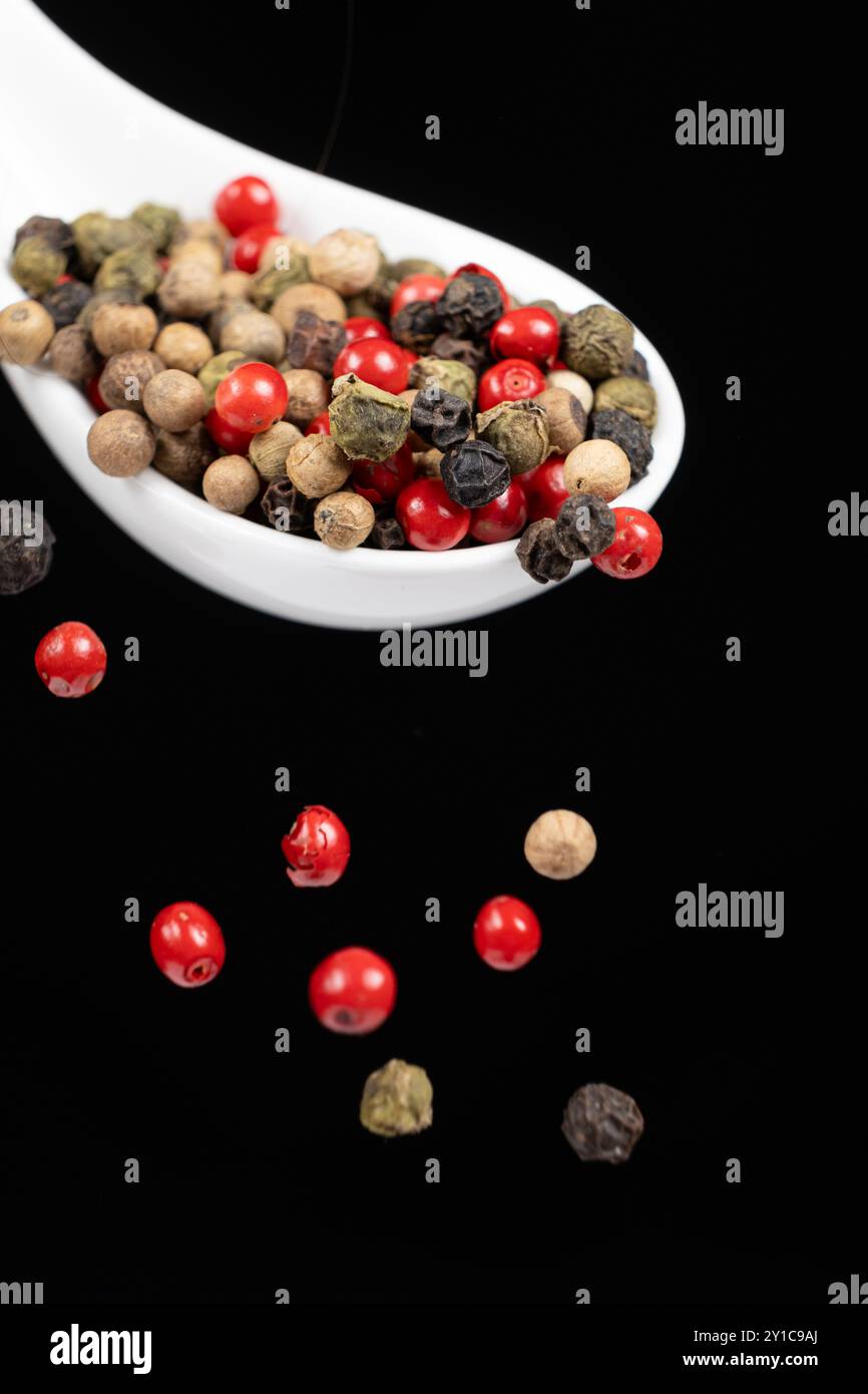 Different types of peppercorns pouring. Red, green, white and black ...