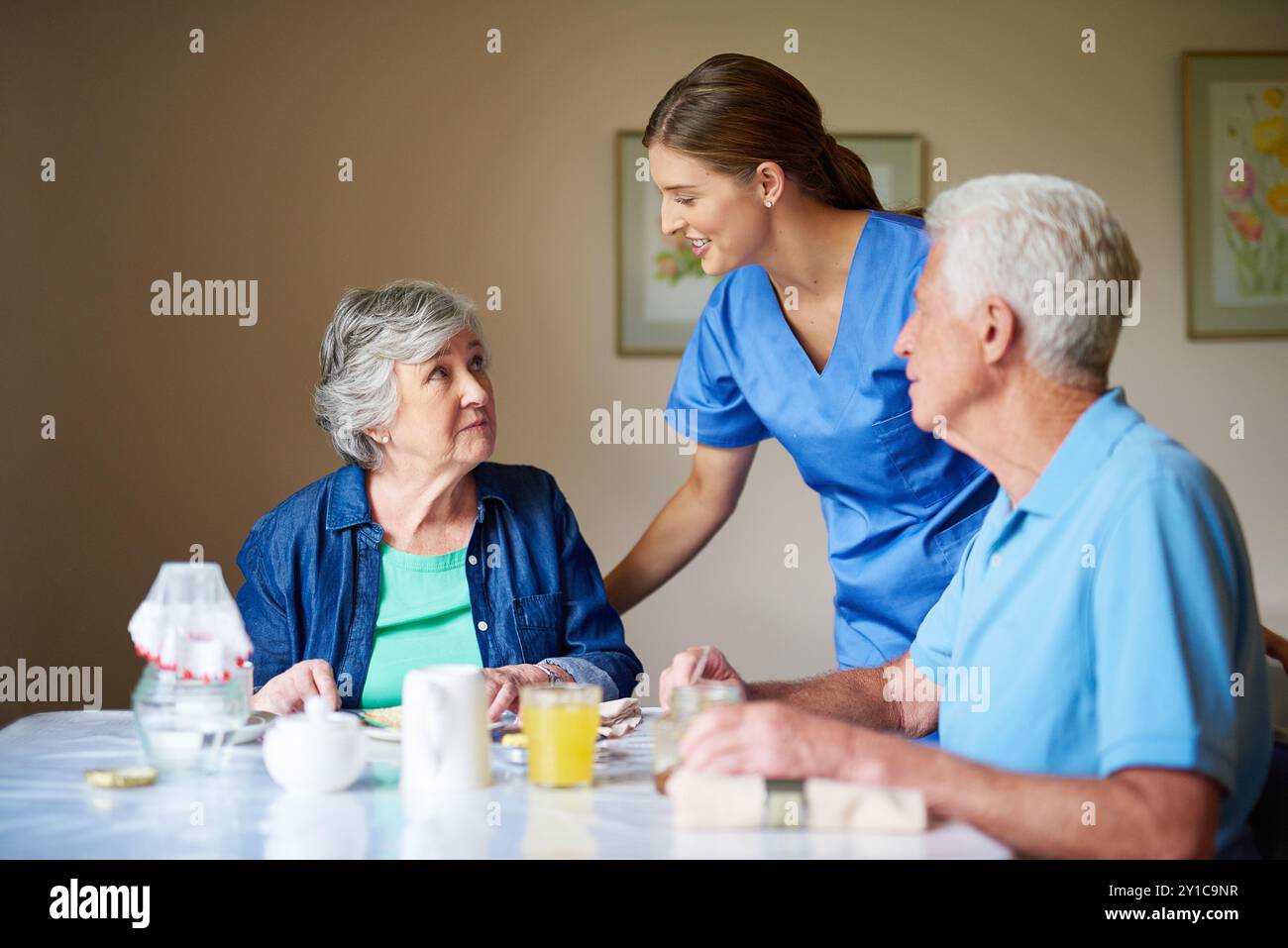 Breakfast, nurse and senior couple in dining room of retirement home ...