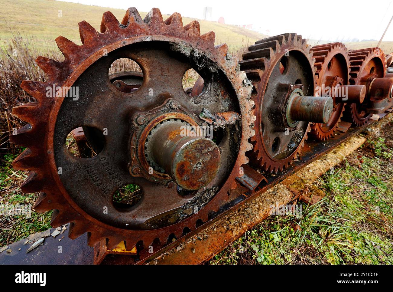 Rusty old gears in a field showing natural decay Stock Photo - Alamy