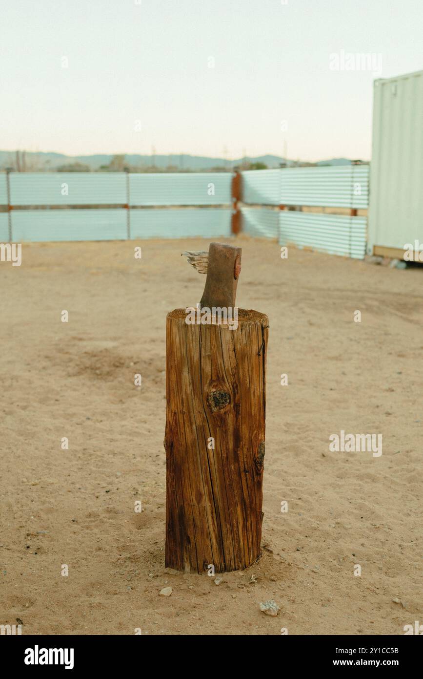 An axe embedded in a tree stump in a sandy yard Stock Photo - Alamy