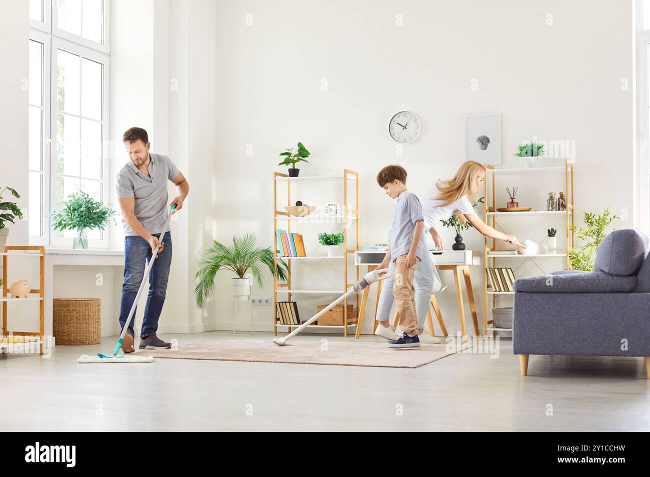 Happy family doing housework, cleaning living room together, using ...
