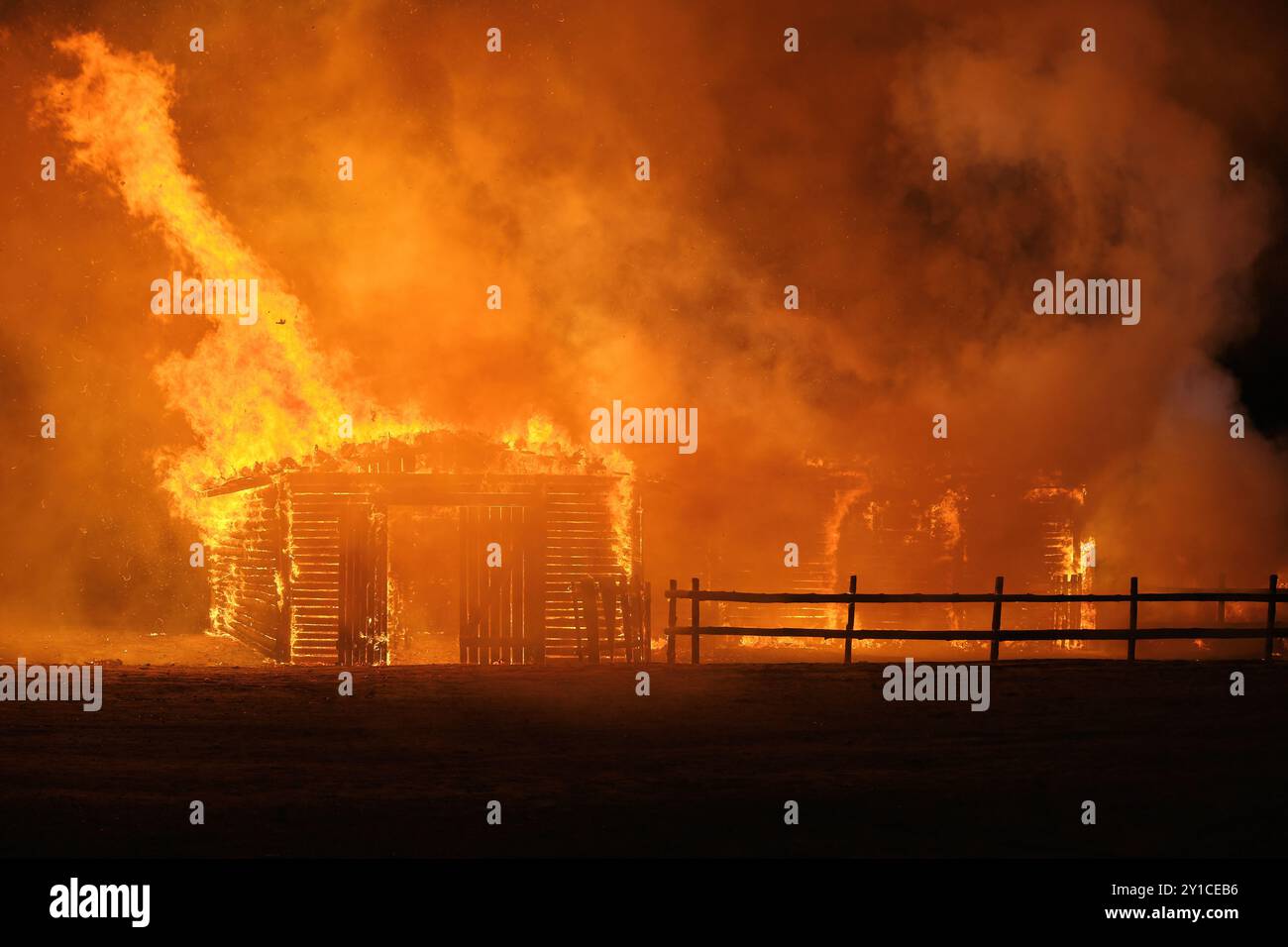 A small wooden house burning at night, sparks fly in the sky Stock ...