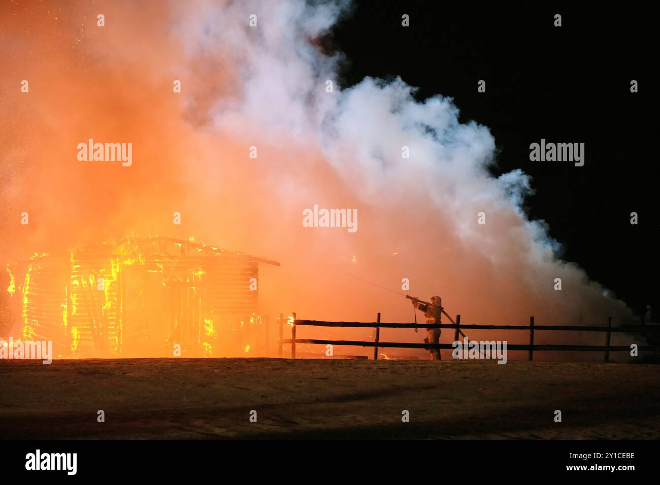 A small wooden house burning at night, sparks fly in the sky and Stock ...