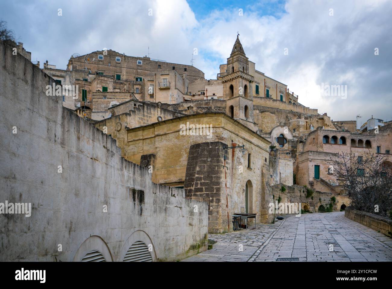 Matera street with traditional houses and Saint Peter church tower ...