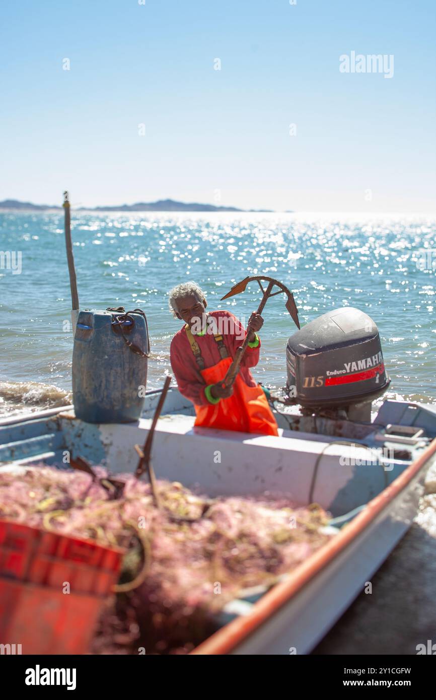 Mexican fisherman holding anchor on boat at shore Stock Photo - Alamy