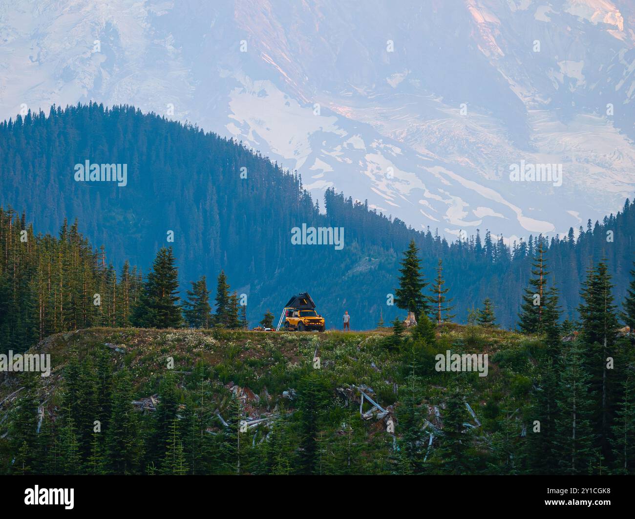 Yellow overlanding truck camping on cliff near Mt. Rainier, Washington ...