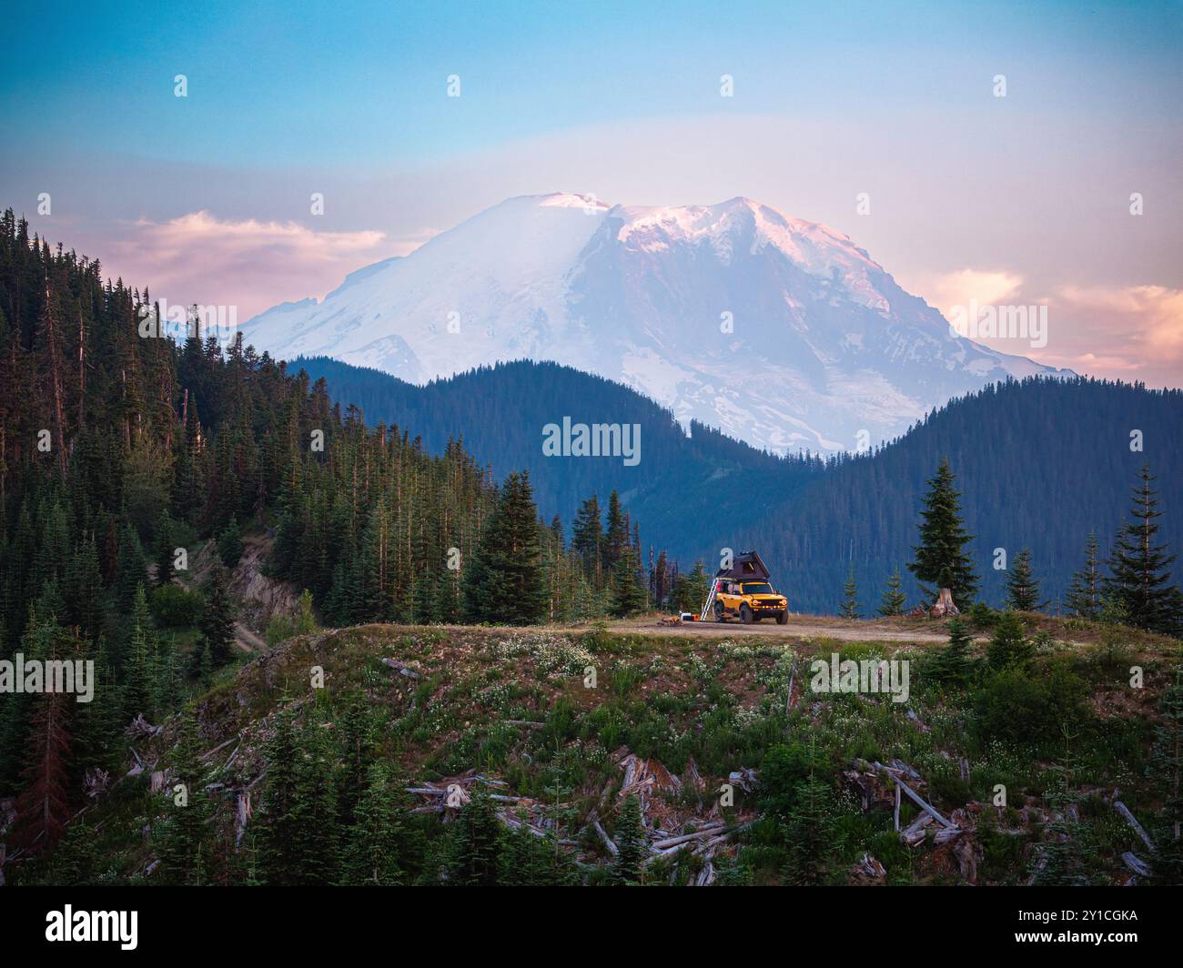 Yellow overlanding truck camping on cliff near Mt. Rainier, Washington ...