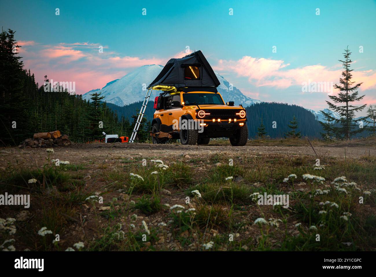 Yellow overlanding truck camping on cliff near Mt. Rainier, Washington ...