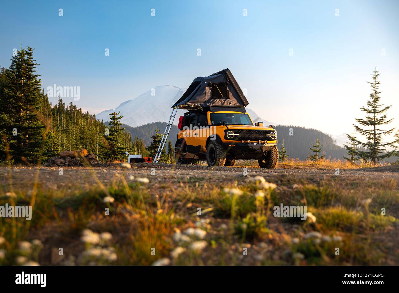 Yellow overlanding truck camping on cliff near Mt. Rainier, Washington ...
