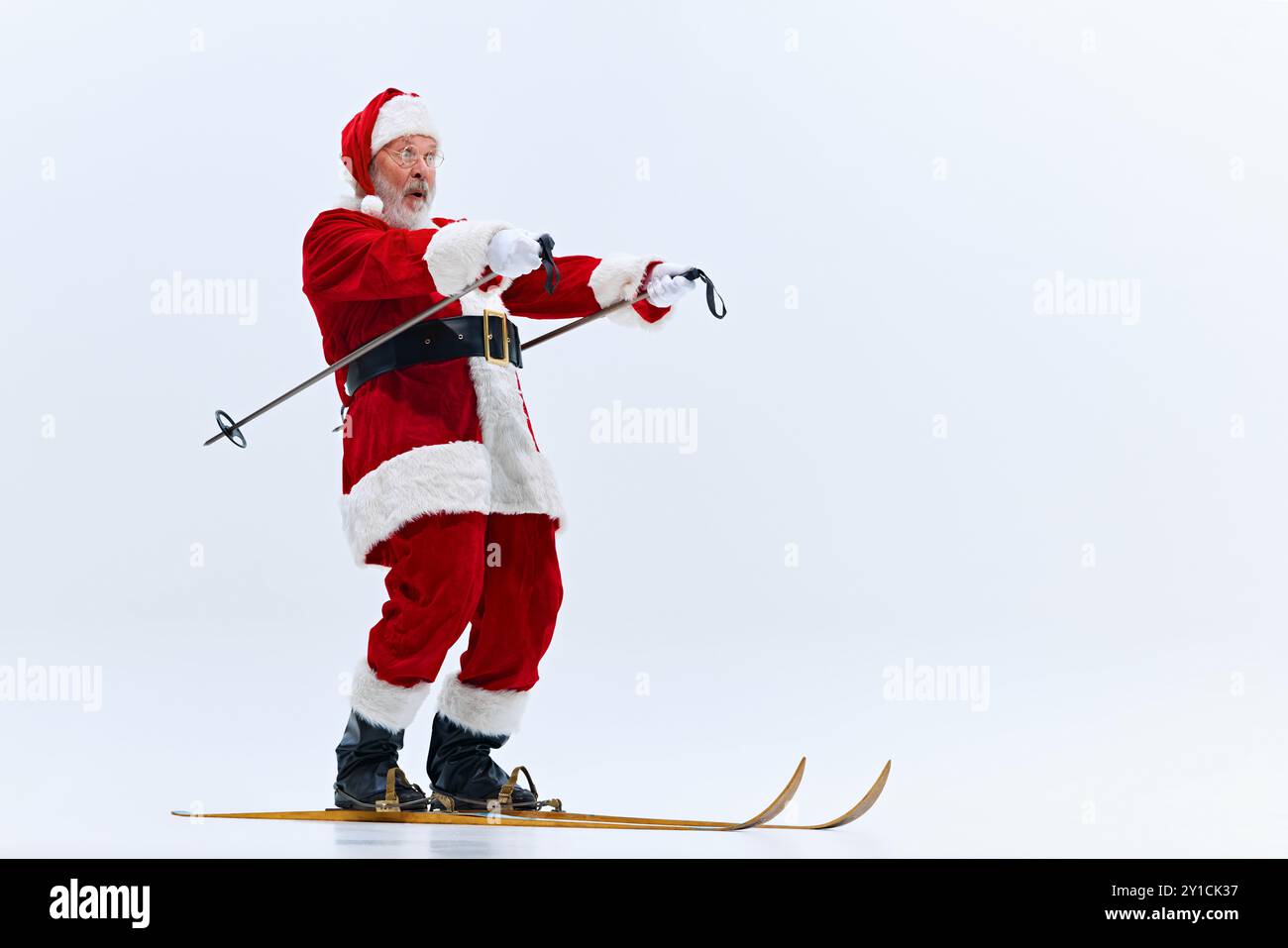 Santa Claus standing on skis, leaning forward, extending ski poles ...