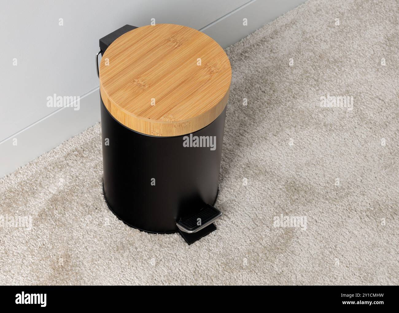 Black Pedal Trash Can with Bamboo Lid on Carpet Stock Photo - Alamy