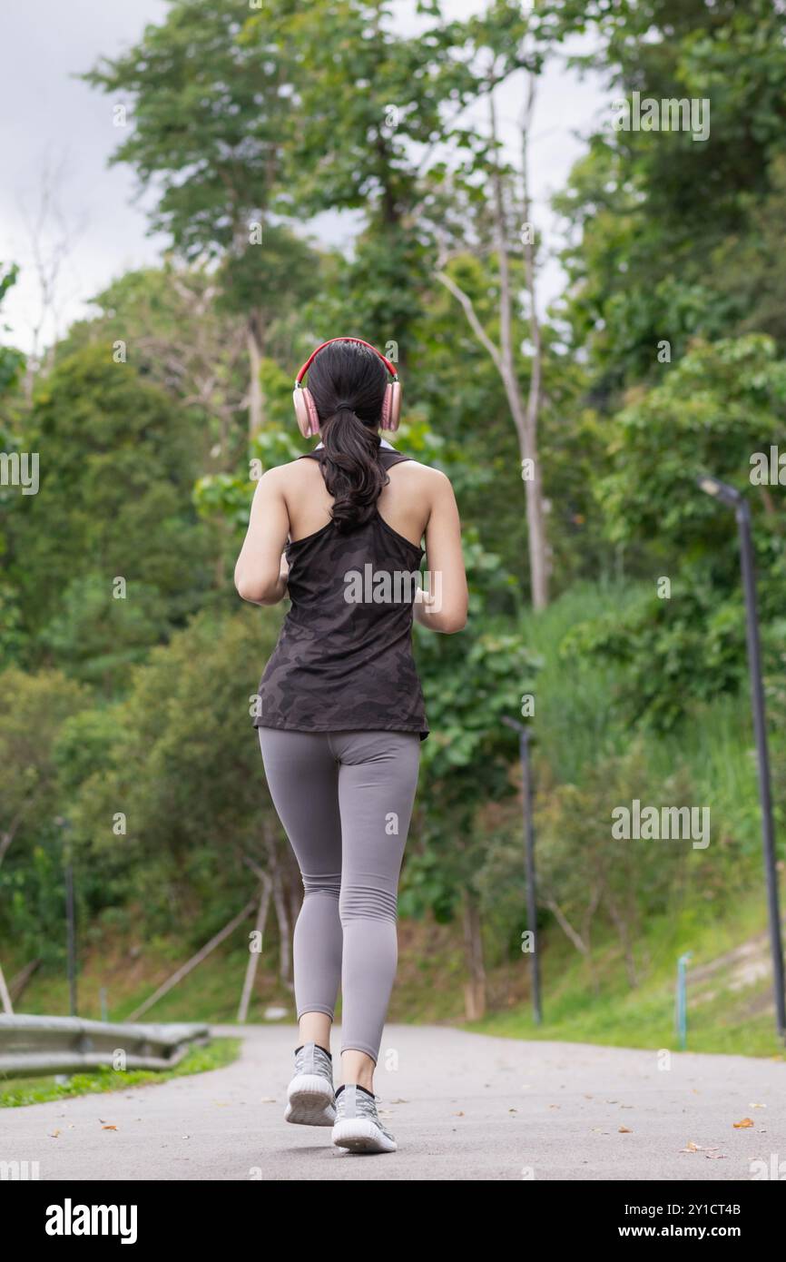young Asian woman wears sports bra and running shoes to go jogging ...