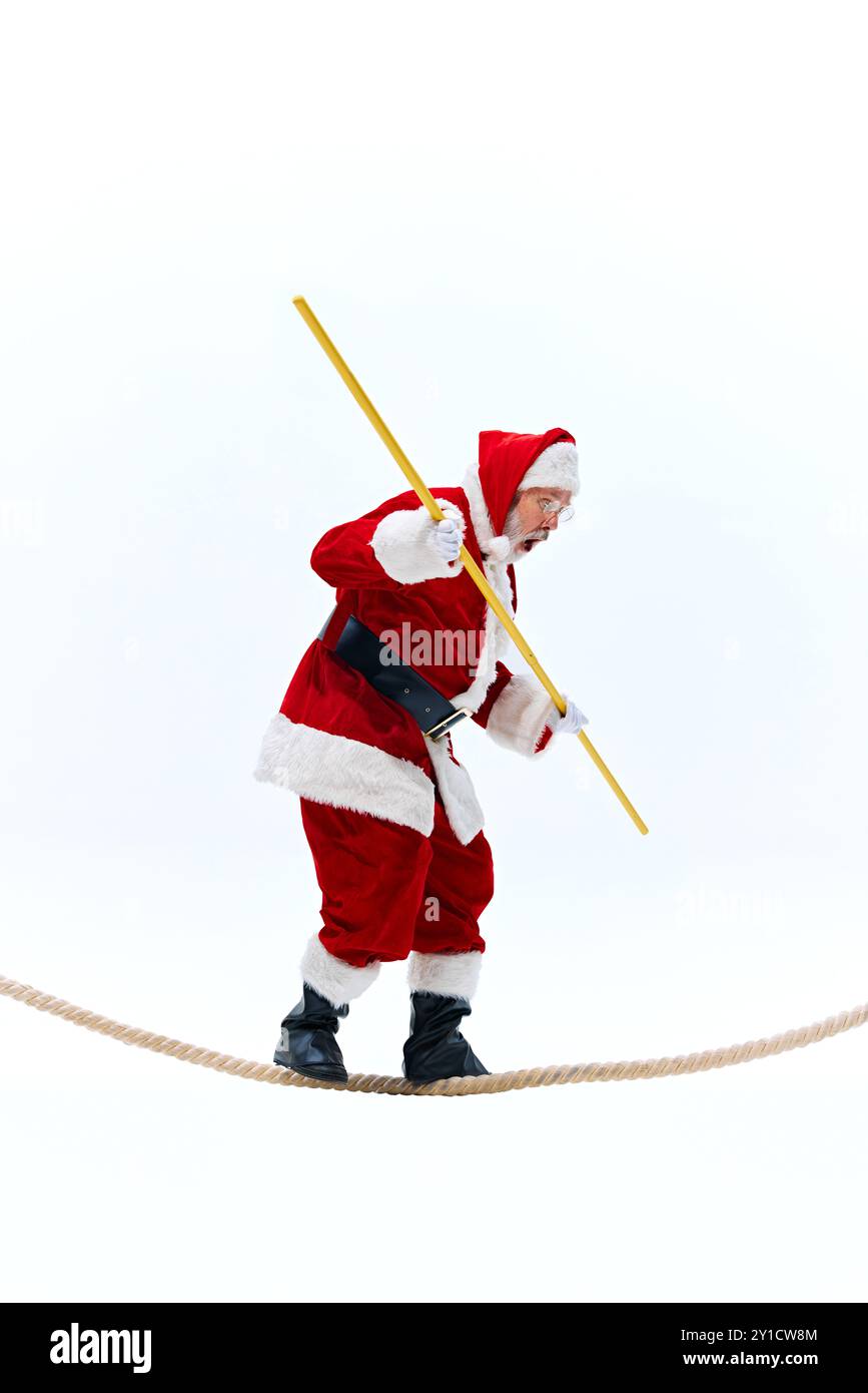 Santa, balancing on tightrope with long pole, looks surprised and ...