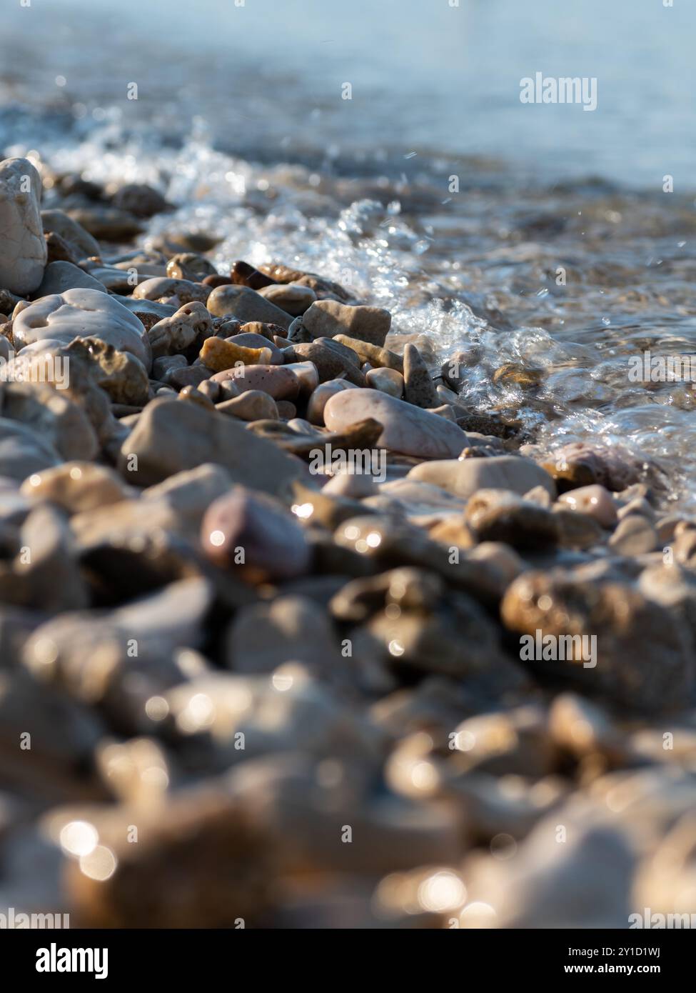 Small wave splashes over pebble on beach Stock Photo - Alamy